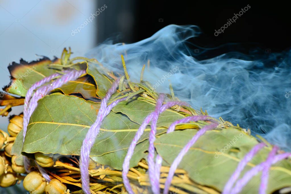 Una escena serena de un ritual de salvia ardiente, con chispas de humo ...